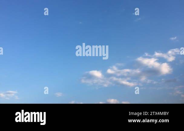 white clouds disappear in the hot sun on blue sky. Time-lapse motion ...