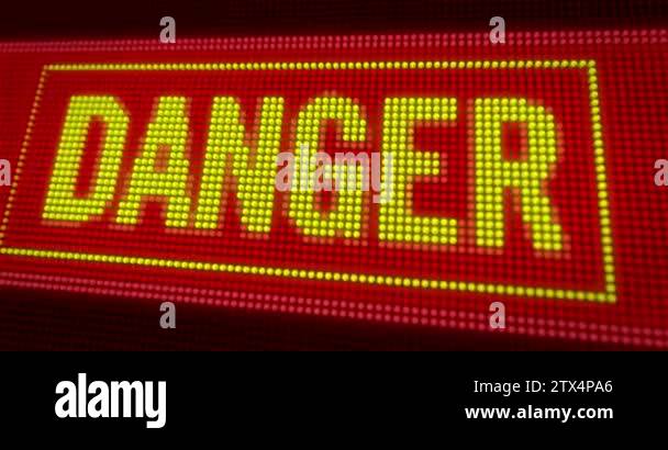 Danger word on big LED display with large pixels. Bright light warning ...