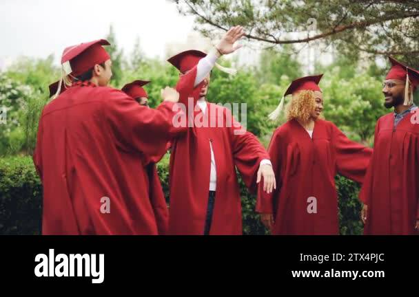 Excited young men and women grads are celebrating graduation day ...