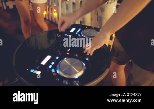 DJs hands are adjusting sound on mixing console creating music while ...