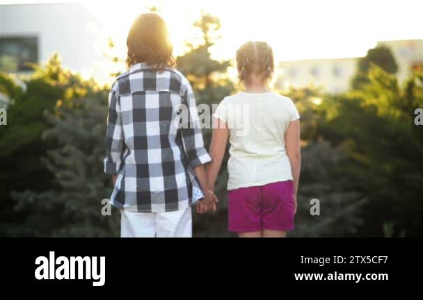 Two Children Stand Back And Hold Hands. Portrait of the Childrens Back ...