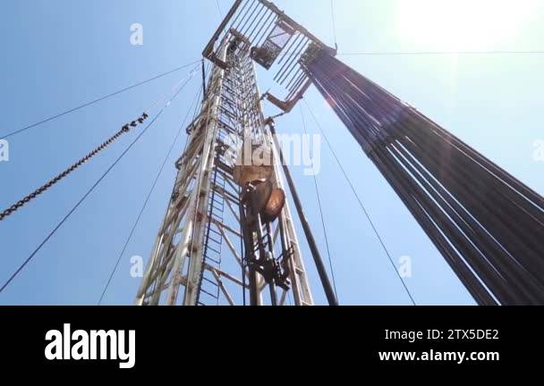 The lifting mechanism of the rig slowly lifts the metal pipe out of the ...