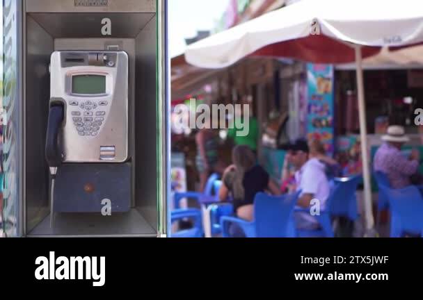 Old telephone booth on a busy street background with people out of ...