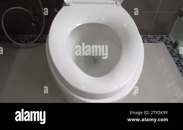 Toilet flushed with water empties from a clean complete flushing ...