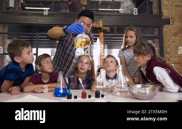 Scientist showing kids how to do chemical reaction experiments in lab ...
