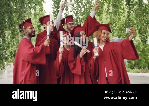 Excited graduating students are taking selfie with smartphone, young ...