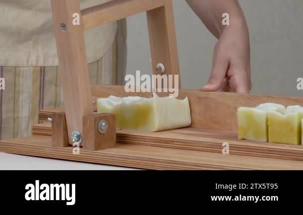 A close-up of woman's hands cutting the soap into bars on the soap ...