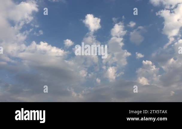 White sunset clouds disappear in the hot sun on blue sky. Loop features ...