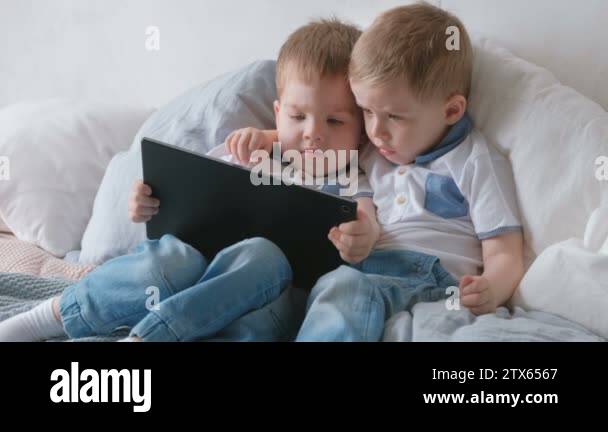 Kids with tablet. Two boys twins toddlers looking cartoon at tablet ...