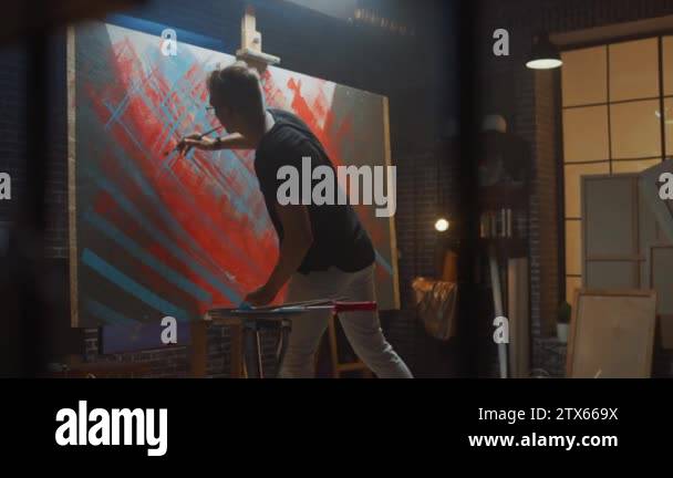 Talented male Artist Works on Abstract Oil Painting, with Broad Strokes ...