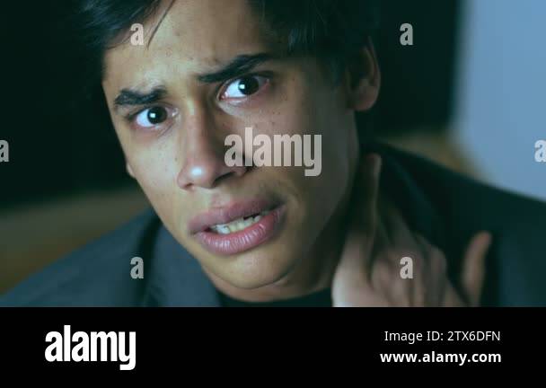 mentally disturbed young man crying and touching his neck staring at ...