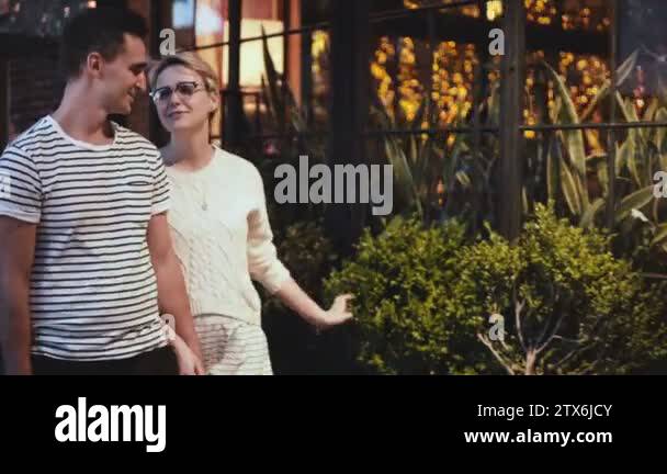 Happy smiling young man and woman hold hands enjoying a date, walking ...