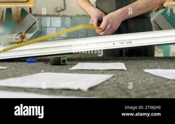 Production and manufacturing of pvc windows, a male worker is measuring ...