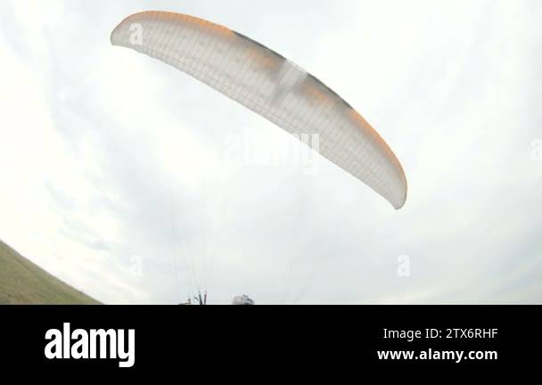medium shot professional paraglider pilot prepares for takeoff raises ...