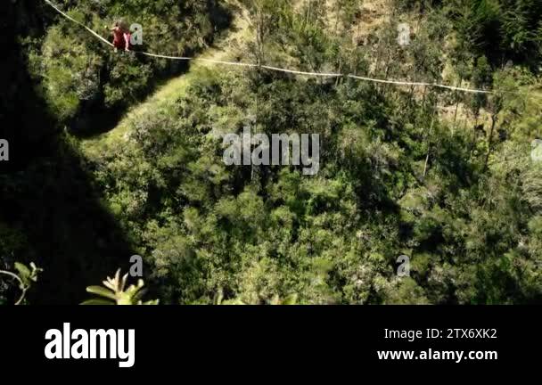 Extremely Male Balancing On Slack Line Or Tightrope High Above The Ground With Green Forest And ...