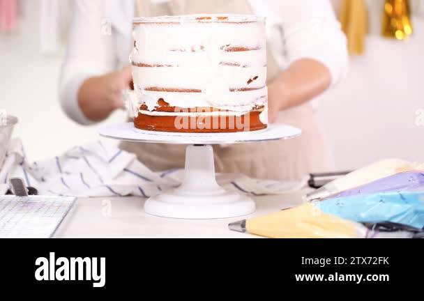 Step by step. Pastry chef stacking cake layers with buttercream ...