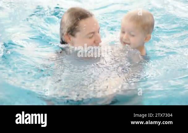Swimming pool. Mom teaches a young child to swim in the pool Stock ...