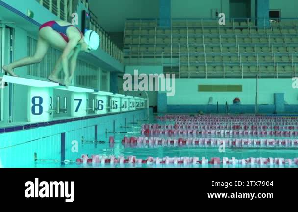 Teenager girl Swimmer Dive In Swimming Pool. Female swimmer dives in ...