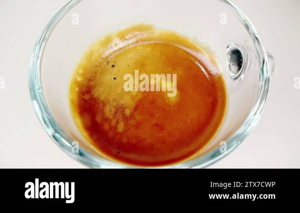 coffee drop falling in slow motion inside of transparent cup of ...