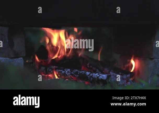 Charred wood in the fire. Burning wood in bright flames in the dark ...