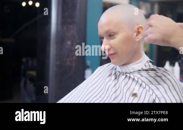 concept of hair loss after chemotherapy. the hairdresser shaves the ...