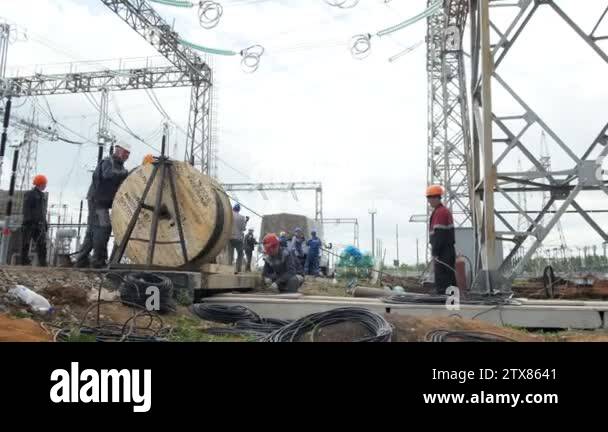 adjusters uncoil steel wire rope from hank at transformer substation ...