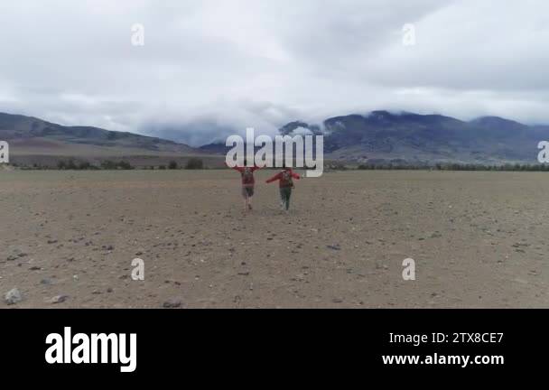 travelers run and joyfully wave their arms. guy and girl tourists are ...