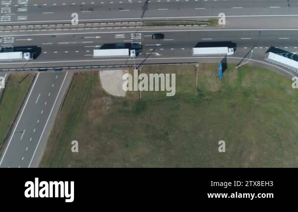 Convoy of trucks ride on the highway bridge, road junction near forest ...