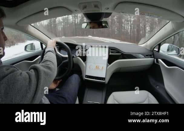 TESLA AUTONOMOUS CAR, MARCH 2017: Adult man maneuvering automated all ...