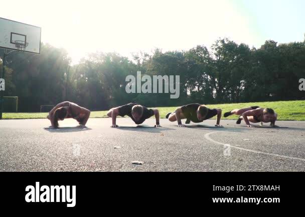 two women with two men doing alligator push ups at stadium Stock Video ...