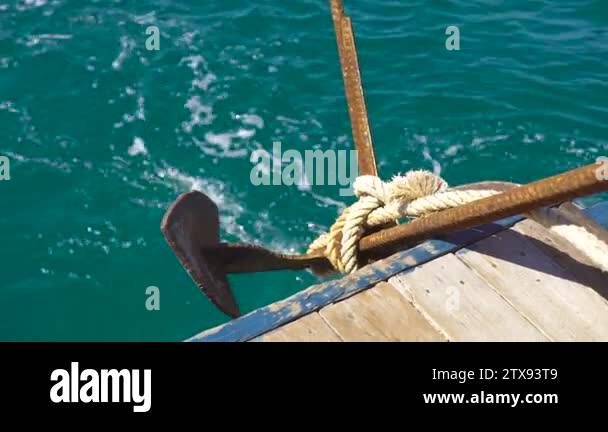 Ship anchor on ship board on turquoise sea water background close up ...