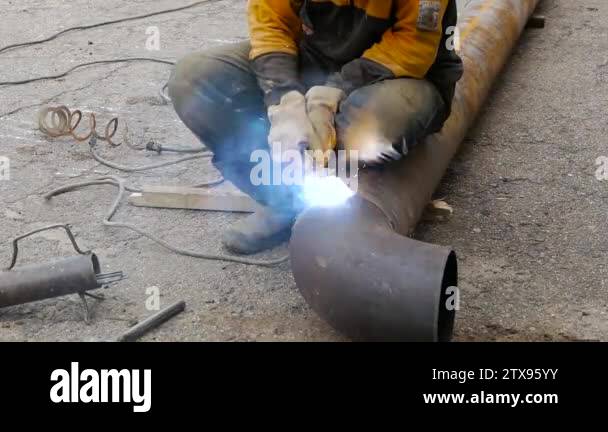 Welding pipeline. Welder worker welding pipe by electrode. Electrodes ...