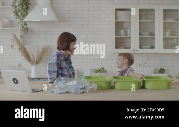 Mother and son sorting plastic and glass waste for recycling. Toddler ...
