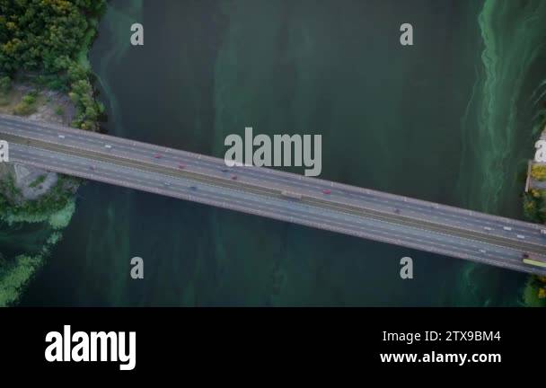 Roads with trucks, trees and green bloom river up view. Algae growth ...