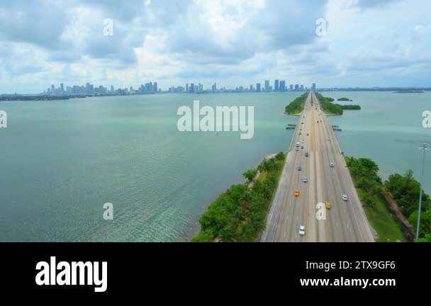Daytime aerial shot over cars crossing bridge on top of water in Miami ...