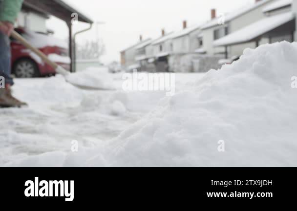 SLOW MOTION CLOSE UP DOF: Man shoveling manually soft white snow from ...
