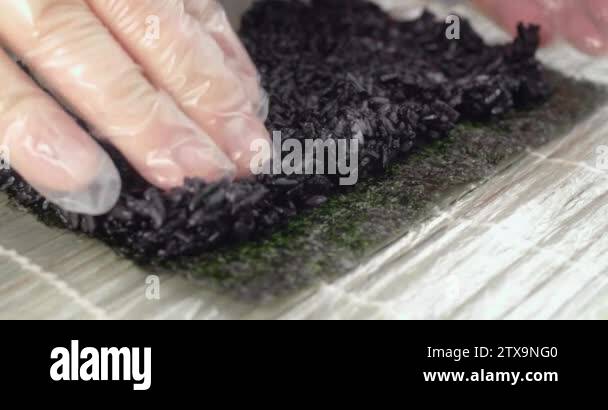 Chef puts black rice on nori and makes sushi roll in slow motion ...