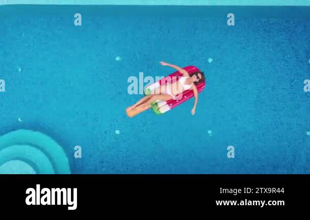 Sexy woman rest and sunbath on a float in the pool, top view aerial ...