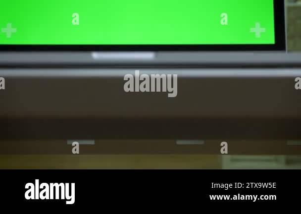 Close-up device on white table, green screen on the laptop, inside ...