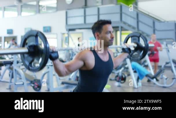 Guy bodybuilder in the gym, works with a barbell, bench press ...