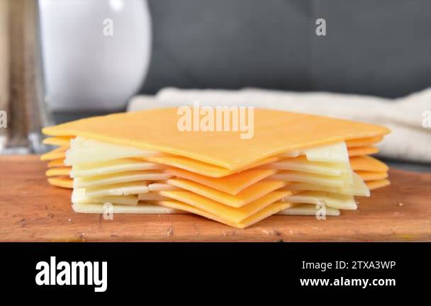 Slices of swiss and cheddar cheese vanishing from a stack, stop motion ...