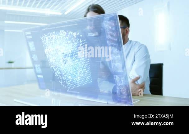 In the Futuristic Laboratory Male and Female Scientists Talk While Working on the Transparent ...