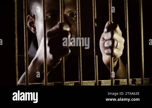 serious black man in prison, behind bars. Justice, prison, crime Stock ...