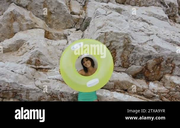 Attractive girl in a swimsuit and a hat is makes a funny twist of an ...