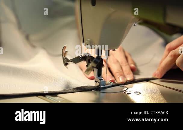 Woman working at a sewing machine, needle sewing machine, female hands, industrial sewing ...