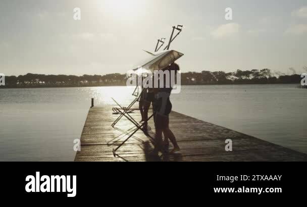 Side view of a team of four young adult Caucasian female rowers ...