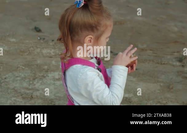 Mother and daughter fry meat and vegetables on a barbecue on the beach ...