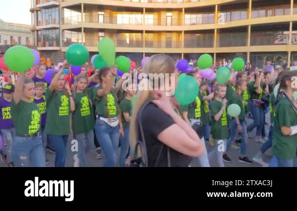 city event, crowd people of different ages with balloons walk along ...