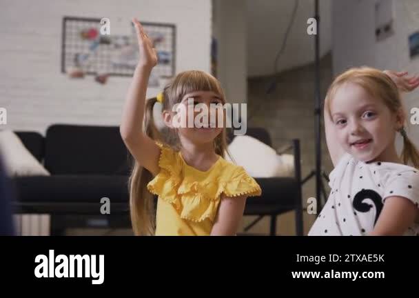 Elementary school girls raise their hands to answer a question which ...