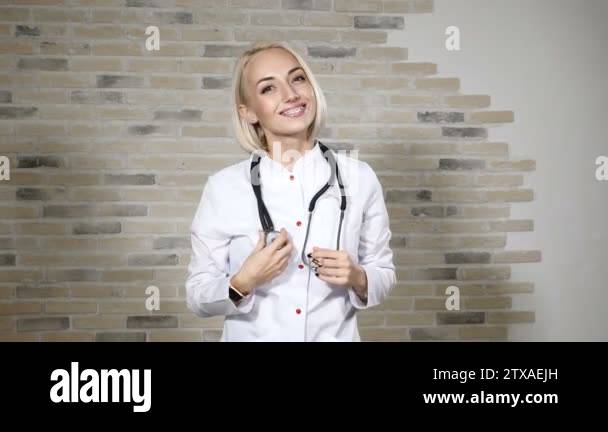 Portrait of young pretty doctor in brace wearing white medical gown ...